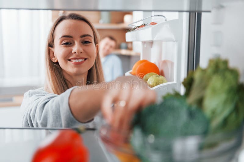 Using Vegetables. Couple Preparing Food at Home on the Modern Kitchen ...