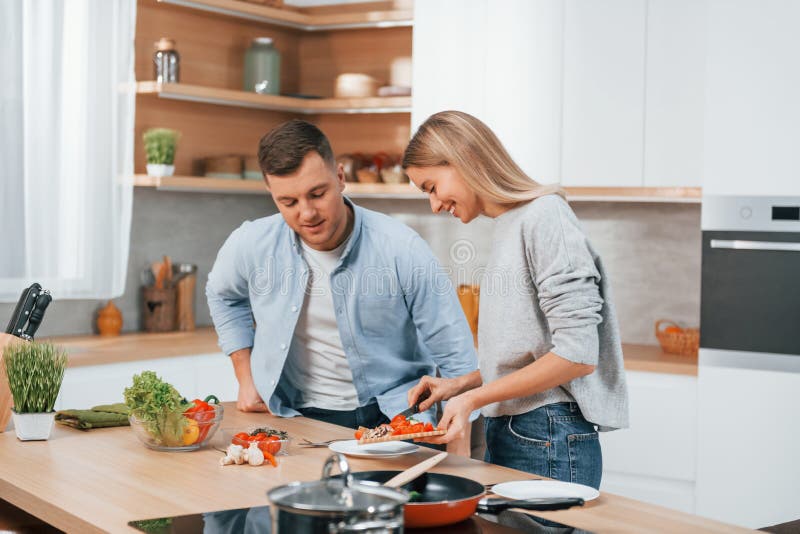 Using Vegetables. Couple Preparing Food at Home on the Modern Kitchen ...
