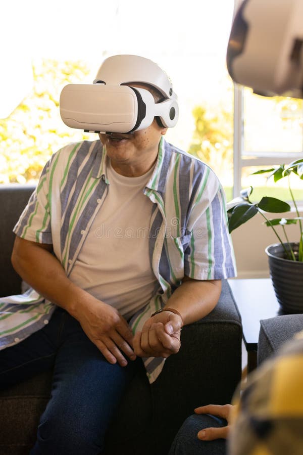Using VR Headset, Man Sitting on Couch in Living Room, Enjoying Virtual ...