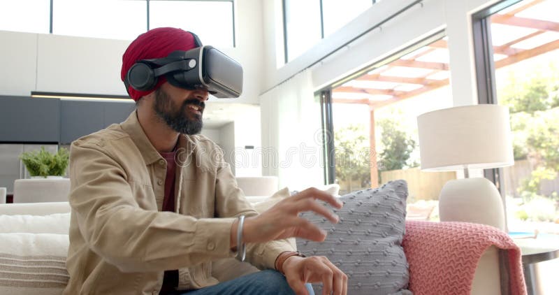 Using VR Headset, Man Sitting on Sofa and Interacting with Virtual ...