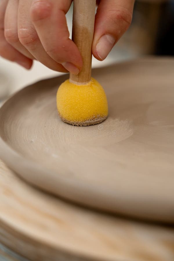 Using Wooden Handle Sponge To Smooth the Surface of a Clay Product in a ...