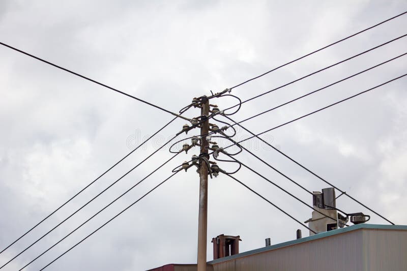Utility Pole with Multiple Overhead Power Lines in Front of Industrial ...