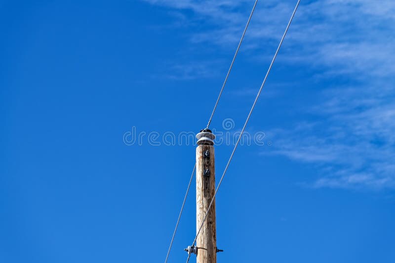 A Utility Pole Supports Two Cables with a Clear Blue Sky Stock Image ...
