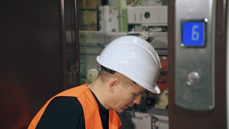 A Utility Worker is Repairing the Equipment of a Passenger Elevator ...