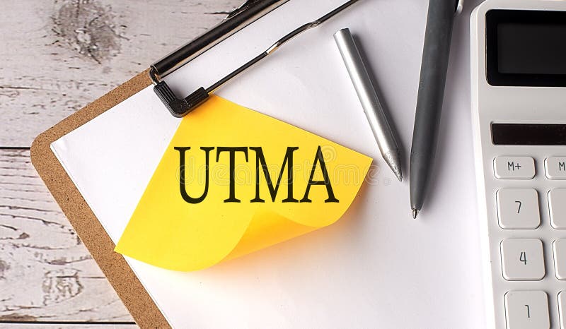 UTMA Word on a Yellow Sticky with Calculator, Pen and Clipboard Stock ...