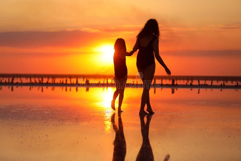 Vacaciones De Verano Familiar Silueta De Mamá Con Hija Pequeña Cogiendo La Mano Caminando