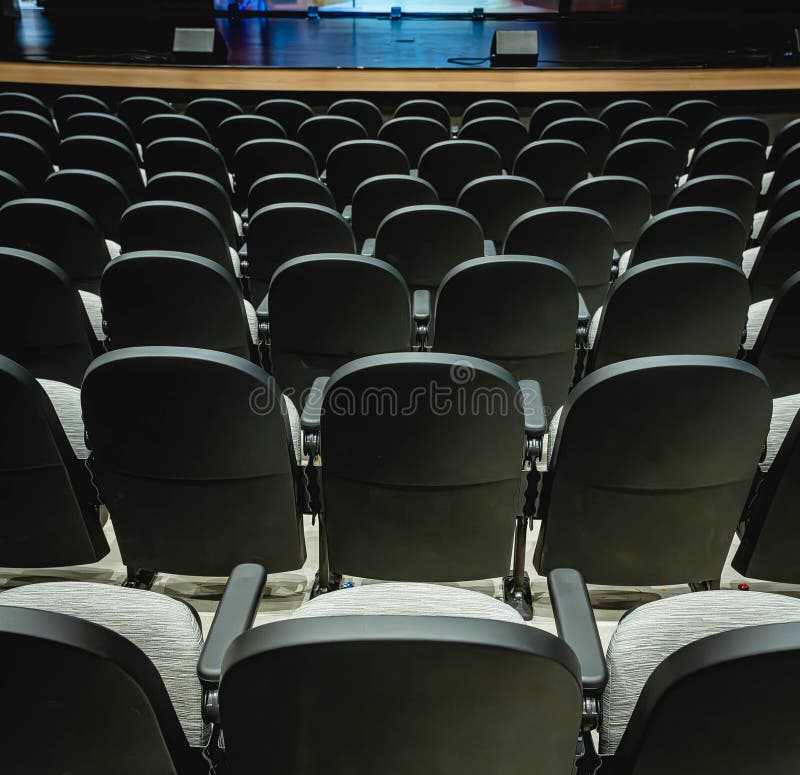 Empty Seats Sit in an Auditorium Under a Spotlight from the Stage Stock ...