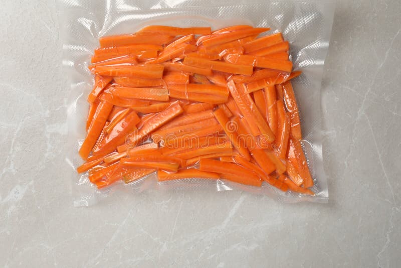 Vacuum Packing with Cut Carrots on Light Grey Marble Table, Top View ...