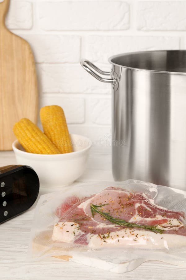 Vacuum Packing with Meat on White Wooden Table. Sous Vide Cooking Stock ...