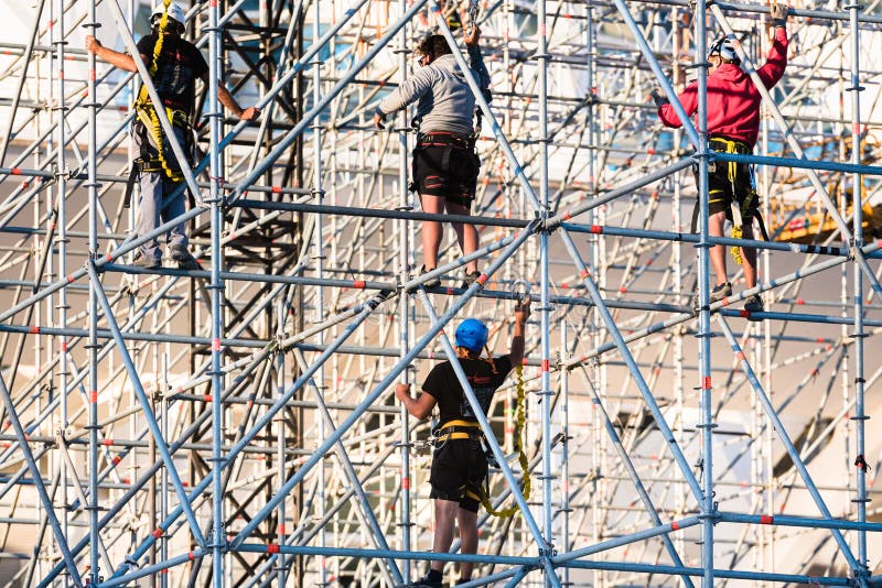 Workers Assembling a Stage for a Concert, Hanging from the Metal Bars ...