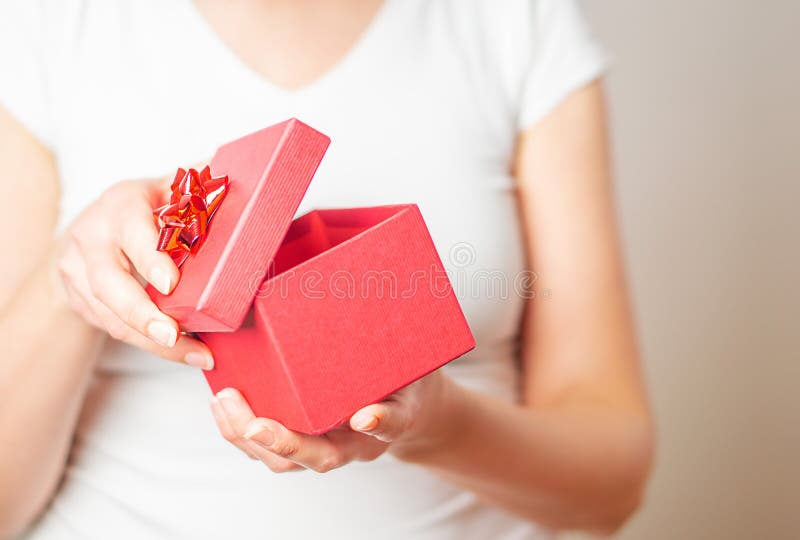 Female Hands Opening a Small Gift in a Red Box with a Heart. Stock ...