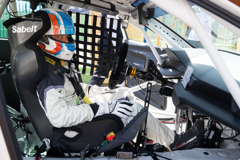 Touring Car Driver with Helmet and Suit Sitting in Cockpit Looking at ...