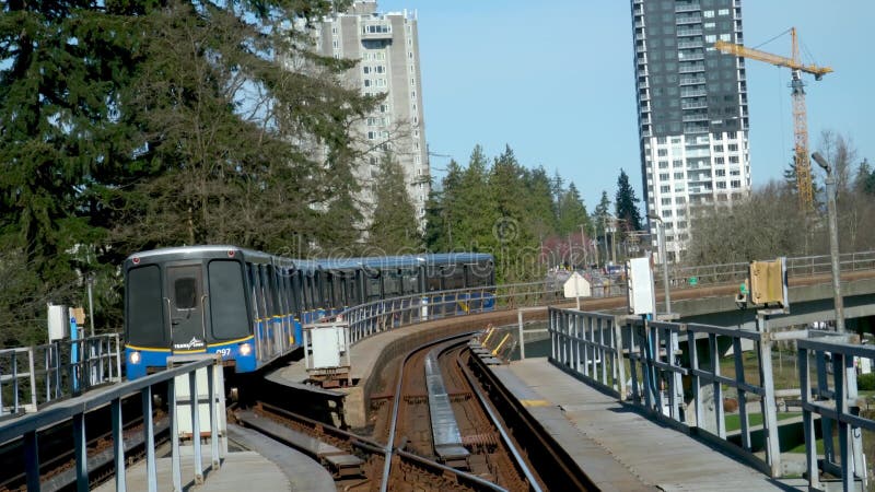 VANCOUVER, CANADA, 2023 BLUE and WHITE SKY TRAIN MOVING in the CENTRE ...