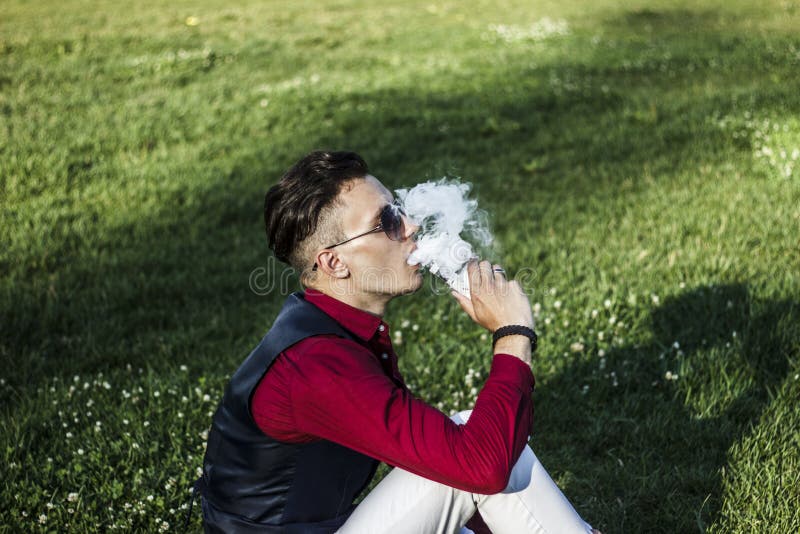 Vaping man in the park stock image. Image of lifestyle - 74585525