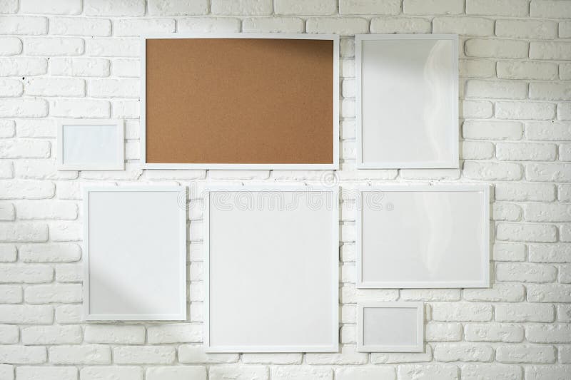 Varied Sized Photo Frames Displayed on a White Brick Wall Stock Photo ...