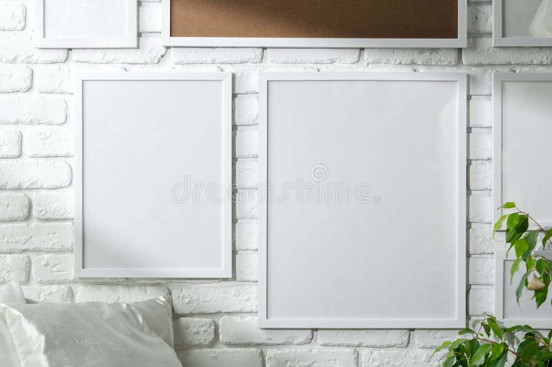 Varied Sized Photo Frames Displayed on a White Brick Wall Stock Photo ...