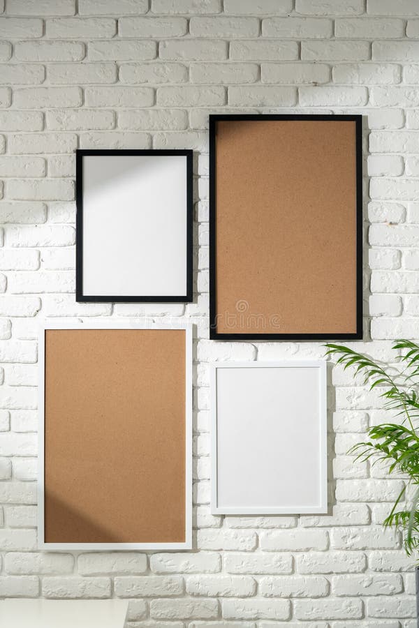 Varied Sized Photo Frames Displayed on a White Brick Wall Stock Photo ...
