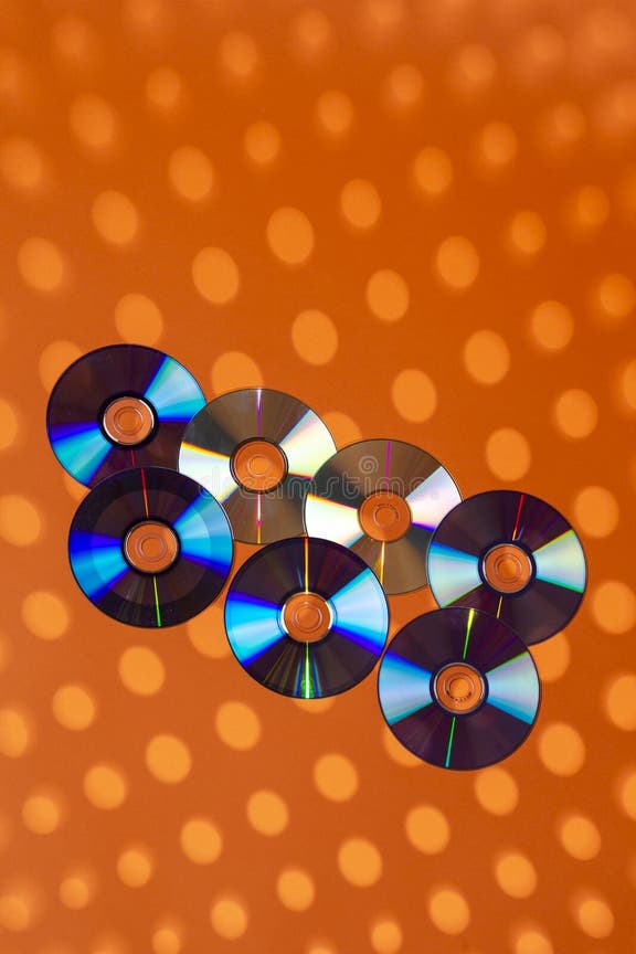 Variety of Arranged CD Disks or DVD Disks on Orange Background with ...