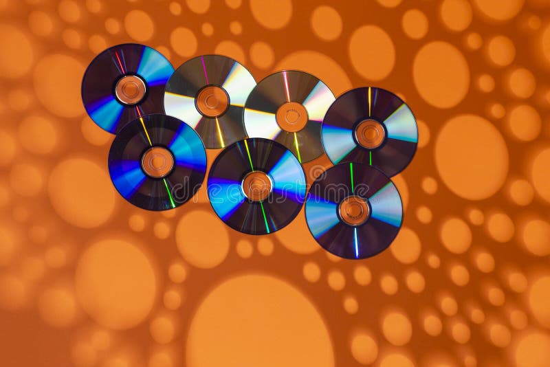 Variety of Arranged CD Disks or DVD Disks on Orange Background with ...