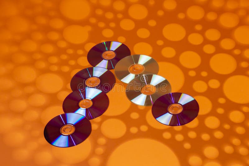 Variety of Arranged CD Disks or DVD Disks on Orange Background with ...
