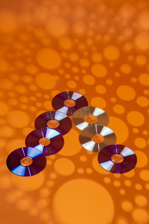 Variety of Arranged CD Disks or DVD Disks on Orange Background with ...