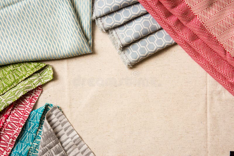 A Variety of Colourful Fabrics Folded and Layed Out Over a Canvas Table ...