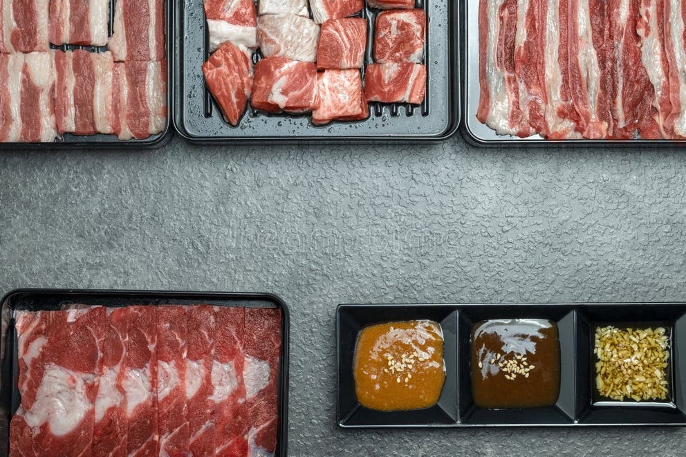 A Variety of Meats are Displayed in Plastic Containers on a Grey ...