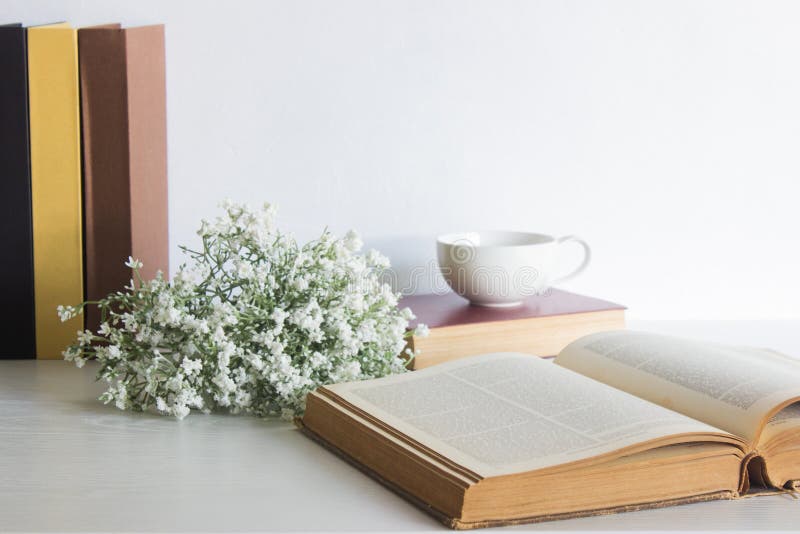 Various Books with White Flowers and Coffee Cup Over the White Table ...