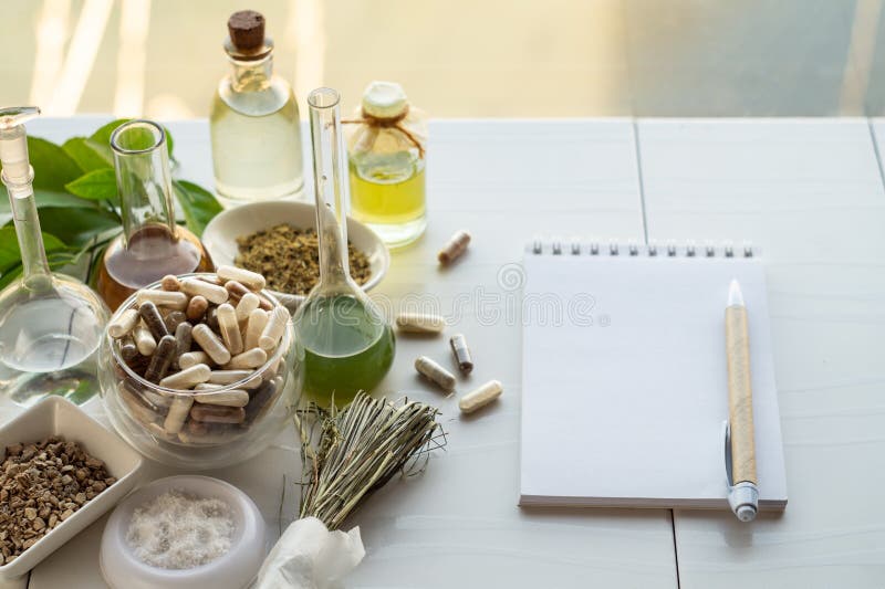 Various Capsules with Dietary Supplements, Ingredients and a Notebook ...