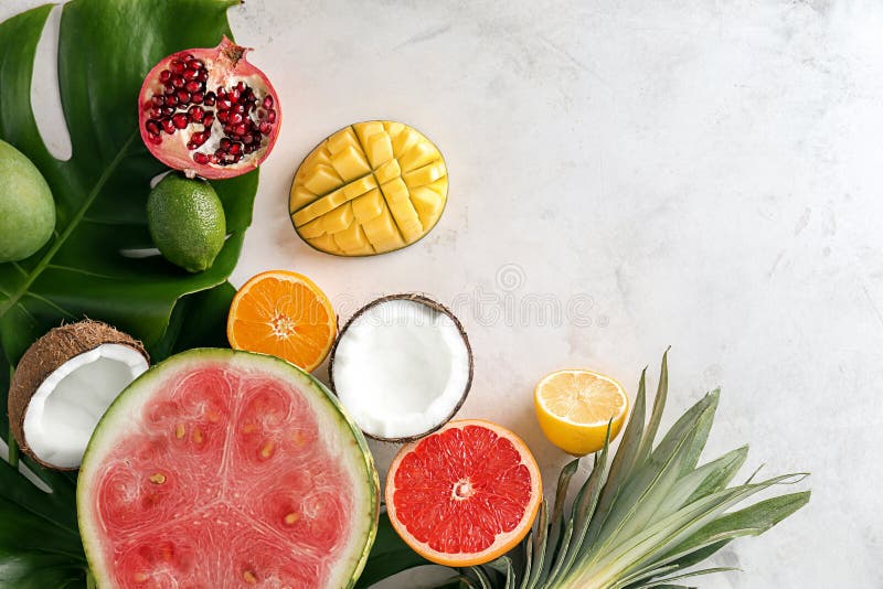 Various Delicious Fruits with Tropical Leaves on Light Table Stock ...