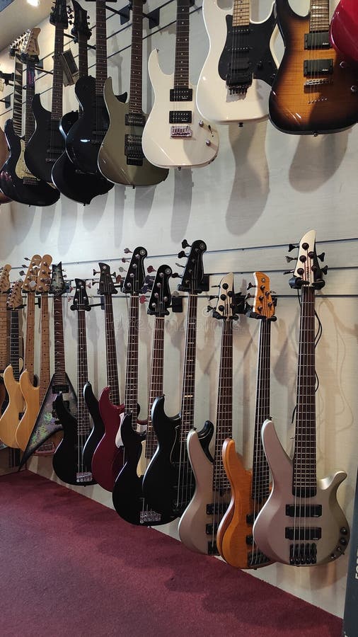 Various Forms of Guitars Lined Up Hanging in a Musical Instrument Shop ...