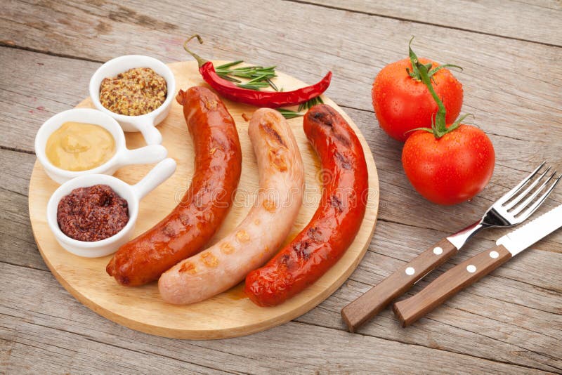 Various Grilled Sausages with Condiments and Tomatoes Stock Image ...