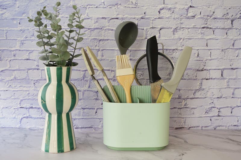 Kitchen Tools Arranged in Pastel Container with Decorative Plant Stock ...