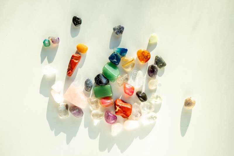Various Multi-colored Semi-precious Polished Stones on a White Table ...