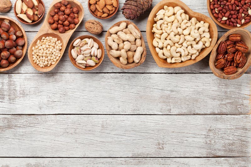 Various Nuts Selection on Wooden Table Stock Image - Image of peanuts ...