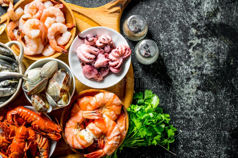 Various Seafood on a Round Cutting Board with Herbs and Spices Stock ...