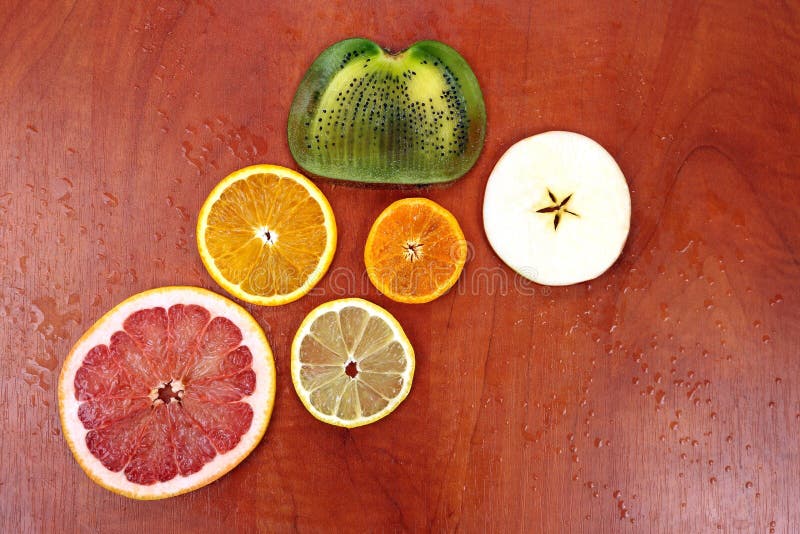 Various Sliced Fruits on Red Wooden Table Stock Image - Image of citrus ...
