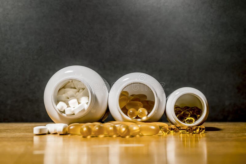 Various Tablets and Capsules in Jars Lie on a Wooden Surface Stock ...