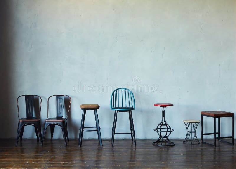 Various Types of Chairs and Stools Stand Against the Gray Wall. Stock ...