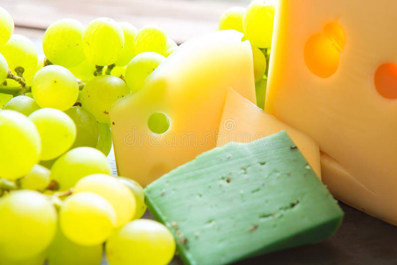 Various Types of Cheese with Green Grapes on Black Slate Cheeseboard on ...
