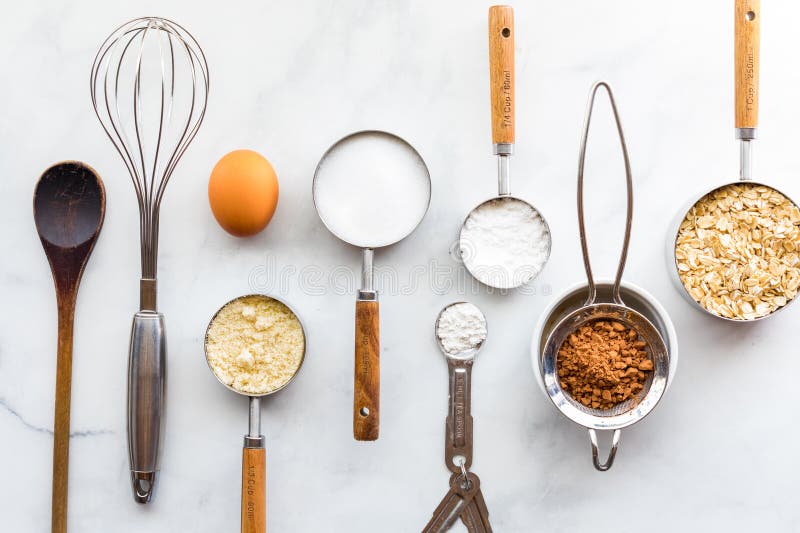 A Row of Various Baking Utensils with Ingredients on a White Marble ...