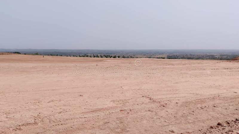 Vast Empty Field of Bare Soil Under Daytime Light Blue Sky with Distant ...