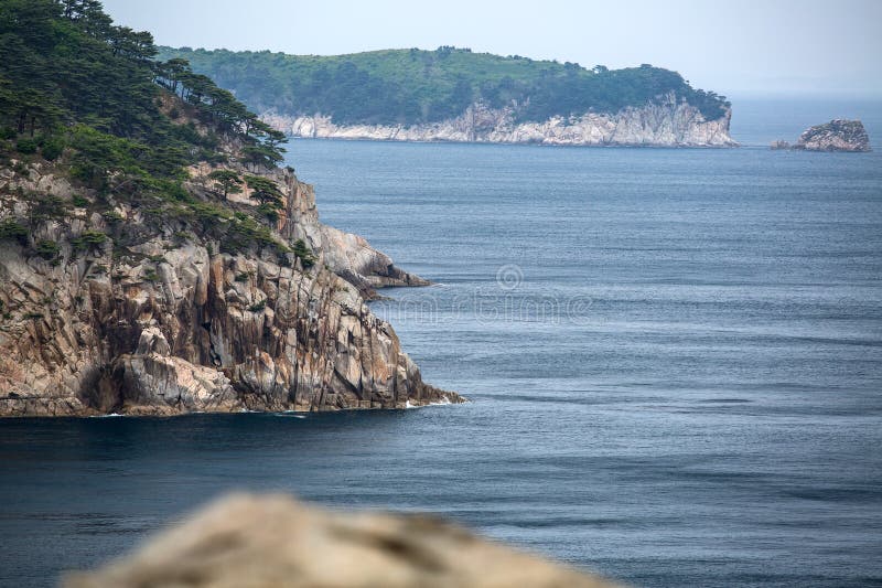 A Vast Expanse of Water Featuring a Towering Cliff in the Foreground ...
