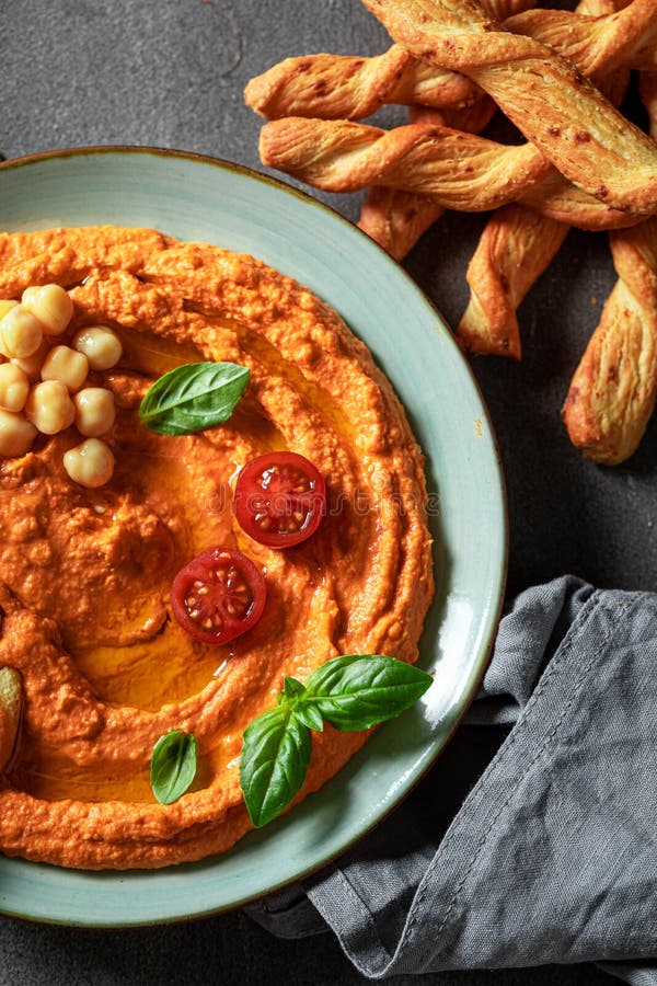 Vegan Tomato Hummus with Breadsticks and Basil Stock Photo - Image of ...