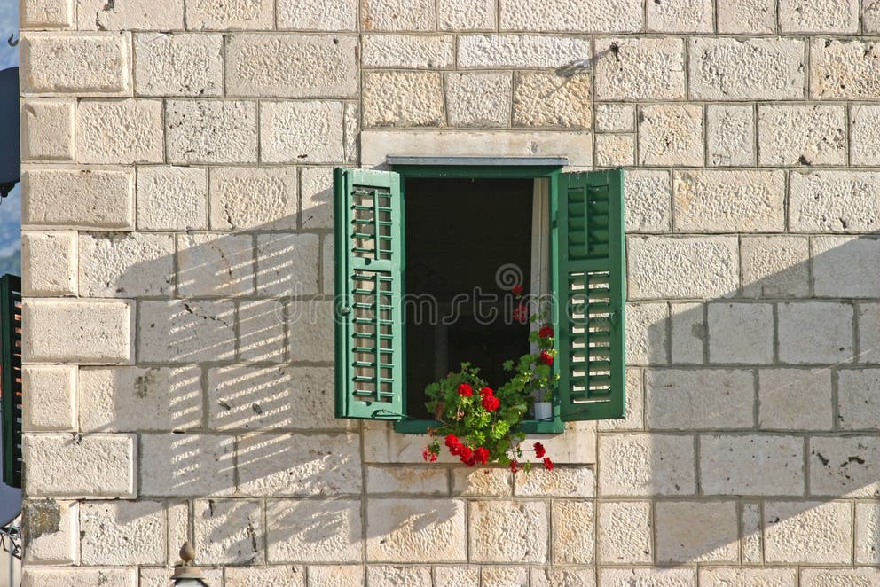 Venster met rode bloemen stock afbeelding. Image of baksteen - 5767405