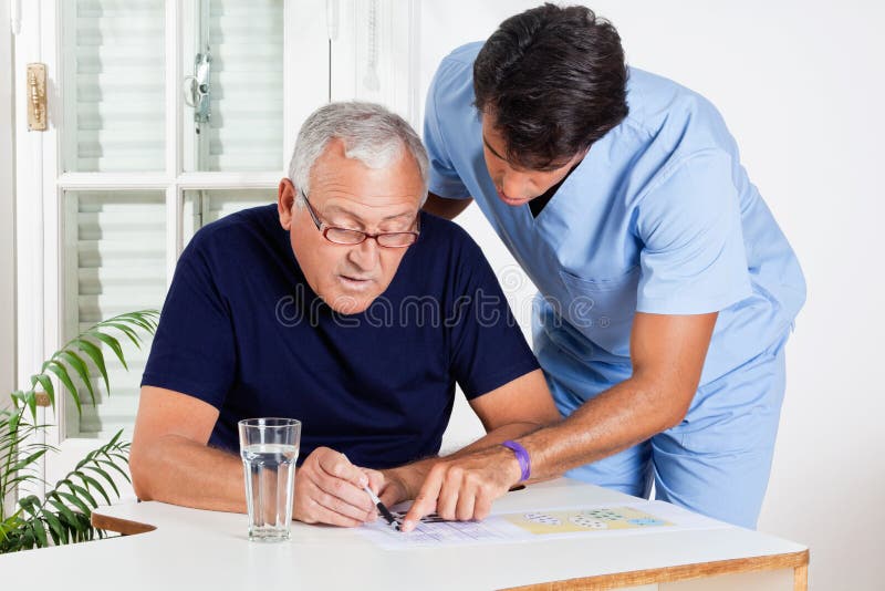 Verpleger Helping Senior Man in Het Oplossen Van Raadsel Stock Foto ...