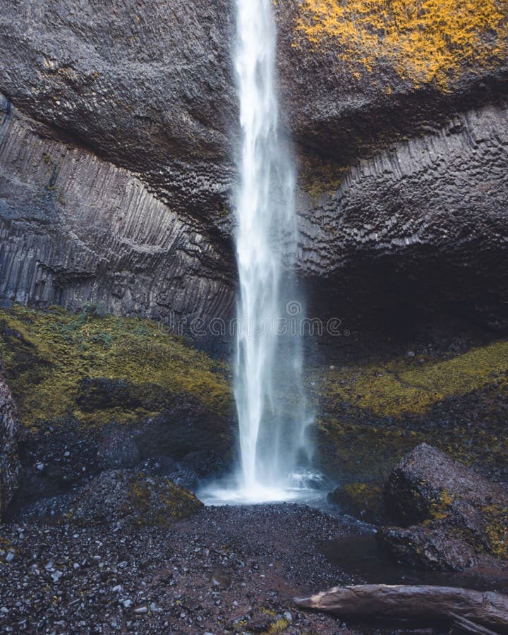 Vertica Shot of a Narrow Waterfall Flowing Over the Mossy Cliffs Stock ...