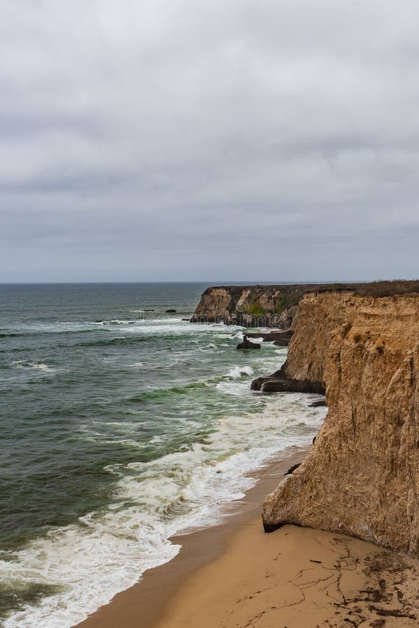 Vertical Aerial Shot of a Wavy Sea with Cliffs on the Right Side Stock ...