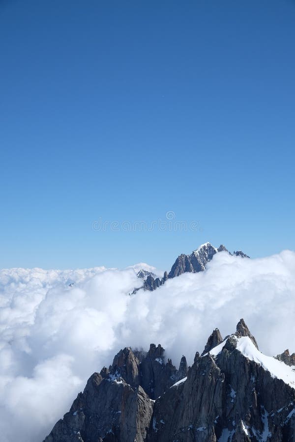 Vertical Aerial View of Alpine Summits in a Sea of Clouds in Clear Blue ...