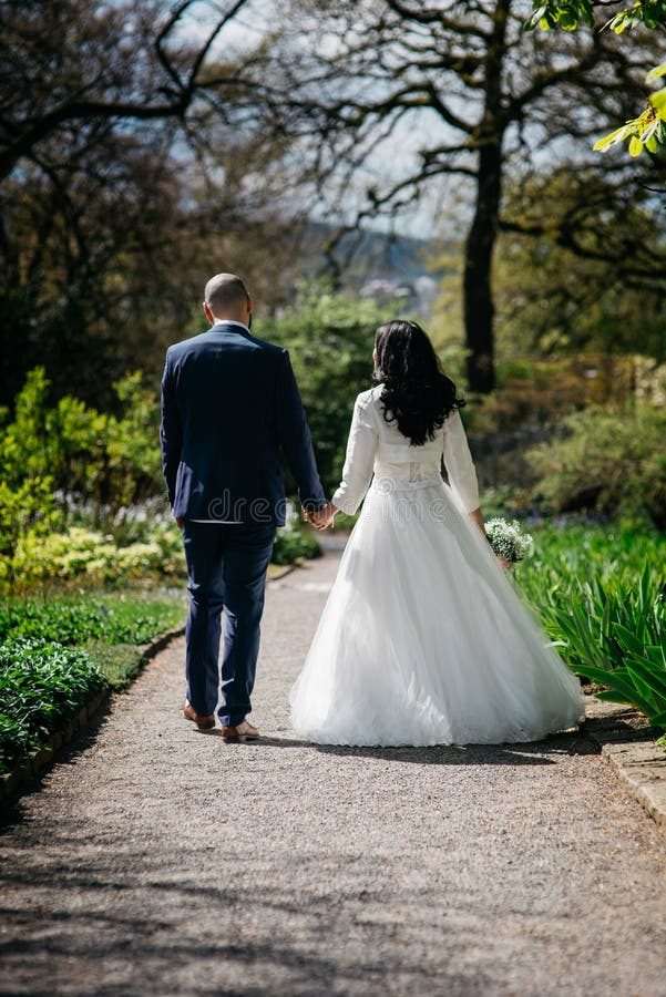 Vertical Back View of the Bride and the Groom Walking in a Park Stock ...
